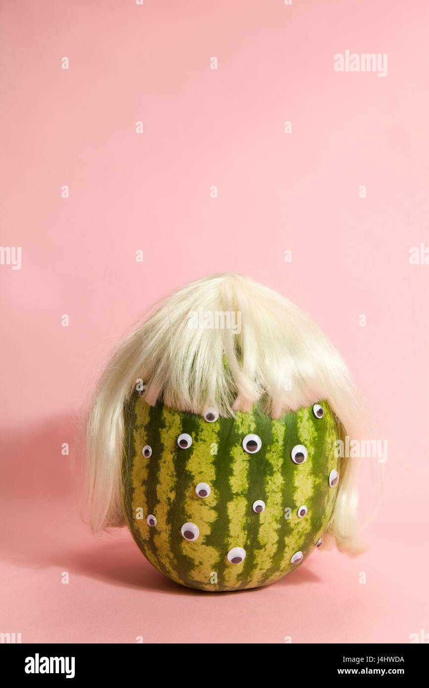 Freak watermelon wearing a wig and crown on a pink background Stock ...