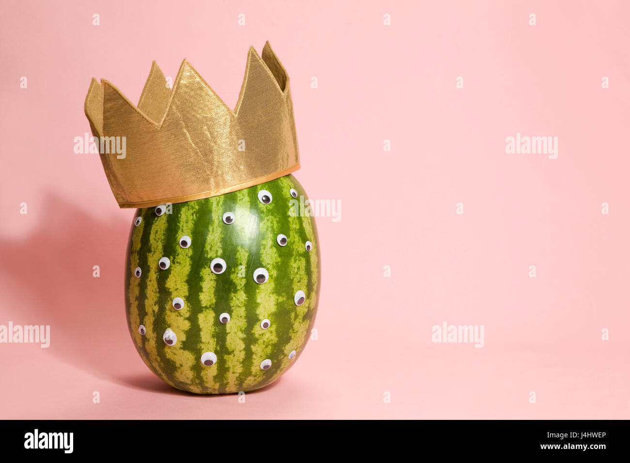 Freak watermelon wearing a crown on a pink background Stock Photo - Alamy