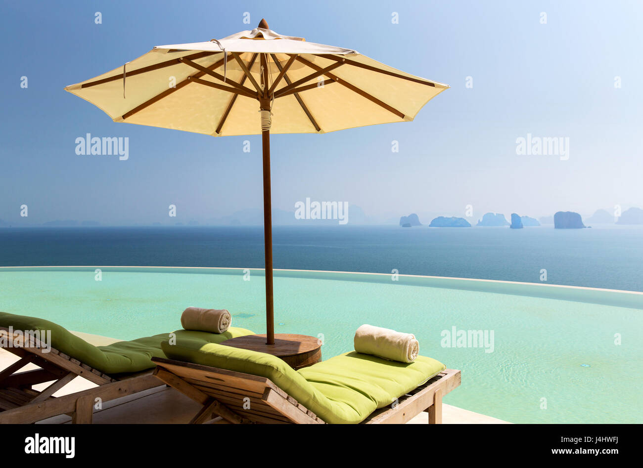 infinity pool with parasol and sun beds at ocean Stock Photo - Alamy