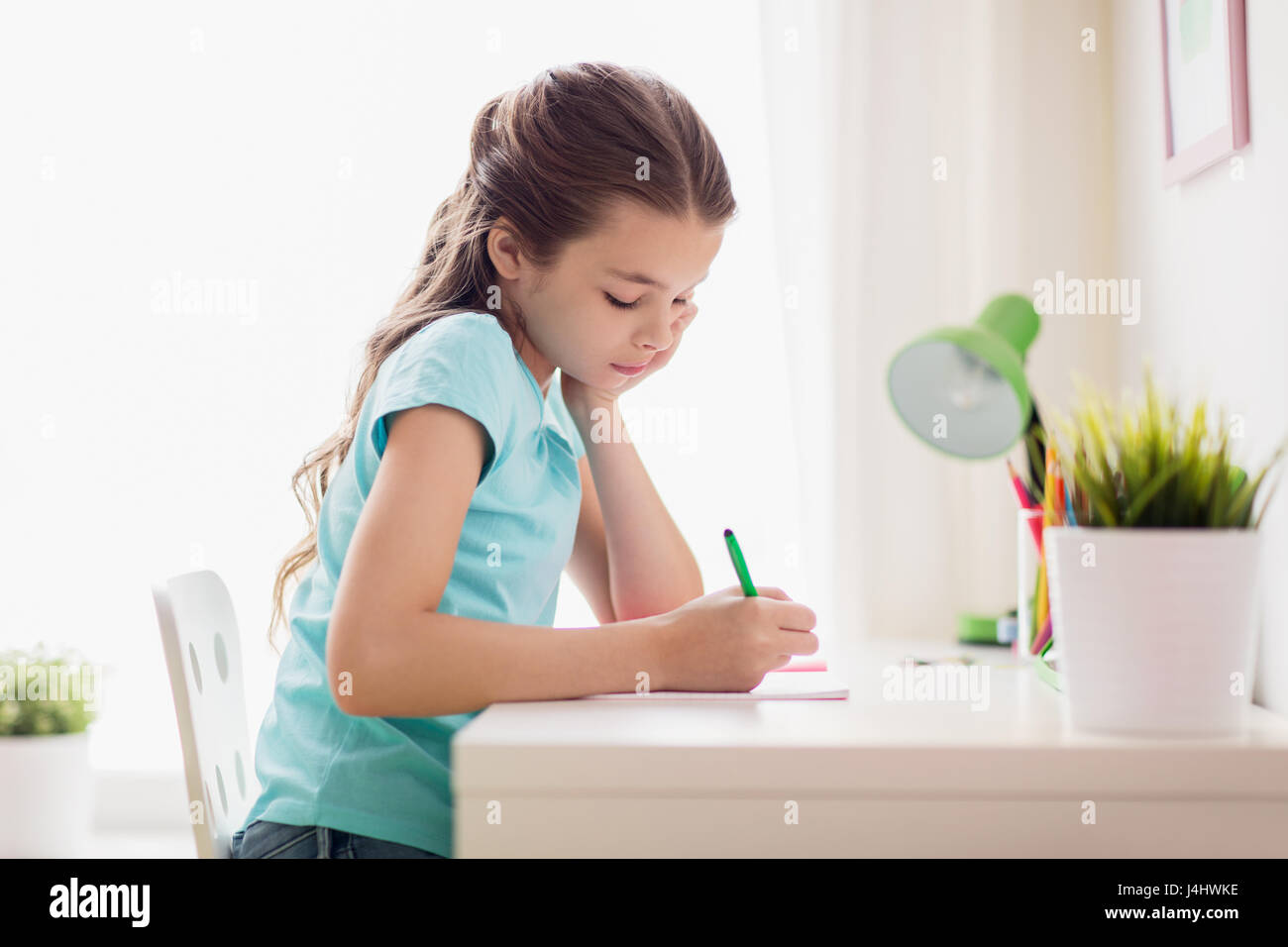 happy girl writing to notebook at home Stock Photo - Alamy