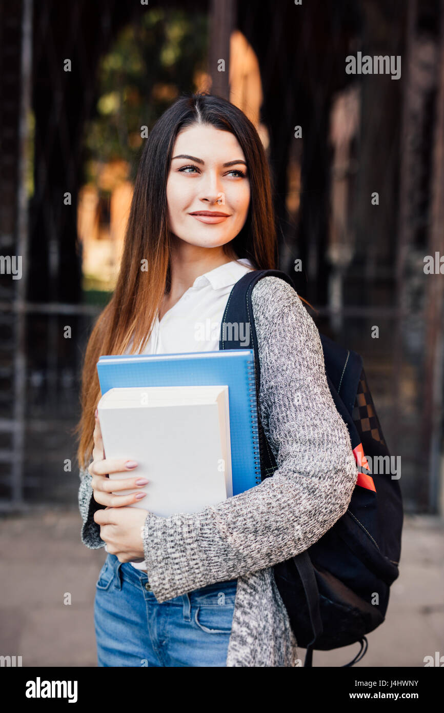 Student with notebooks and bag in front of College University Stock ...