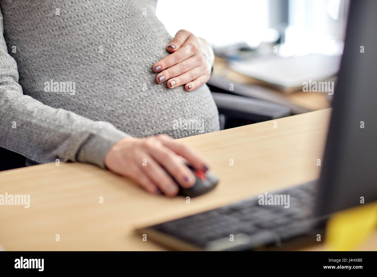 pregnant businesswoman with computer at office Stock Photo - Alamy