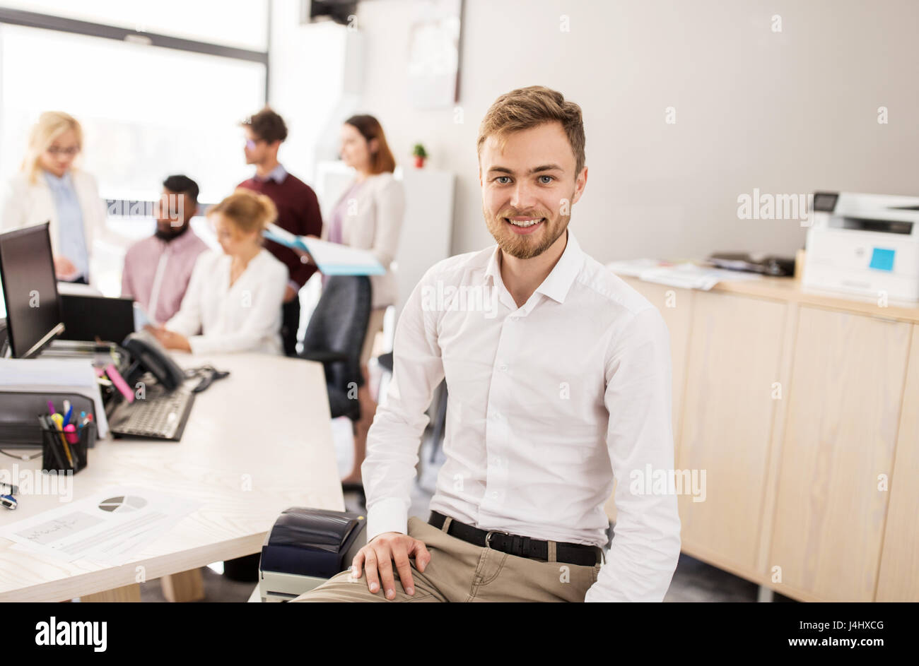 happy young man over creative team in office Stock Photo - Alamy