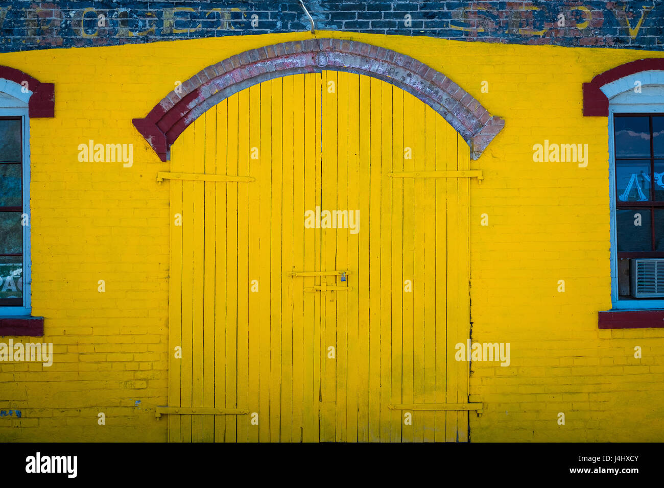 Old garage with door and wall in bright yellow Stock Photo - Alamy