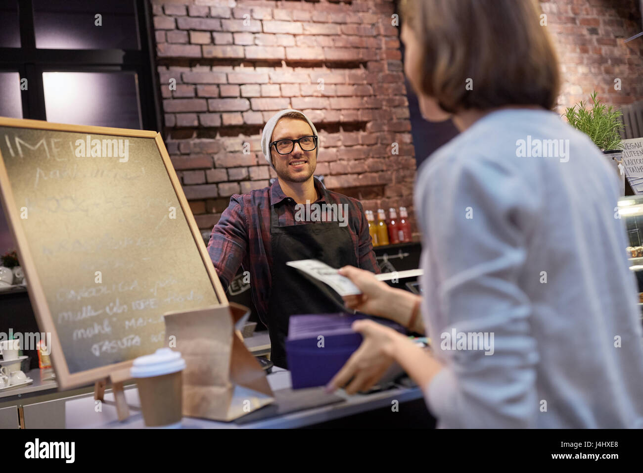 happy barman and woman paying money at cafe Stock Photo - Alamy