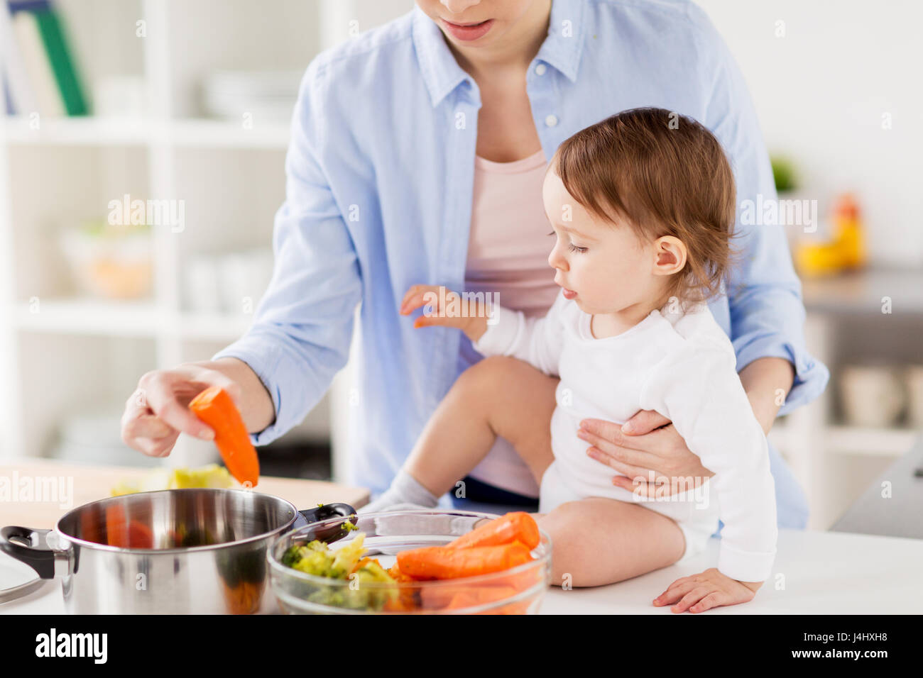 happy mother and baby cooking vegetables at home Stock Photo - Alamy