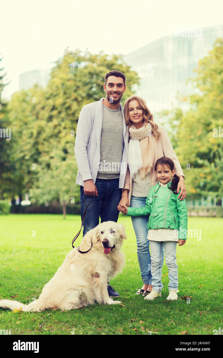 happy family with labrador retriever dog in park Stock Photo - Alamy