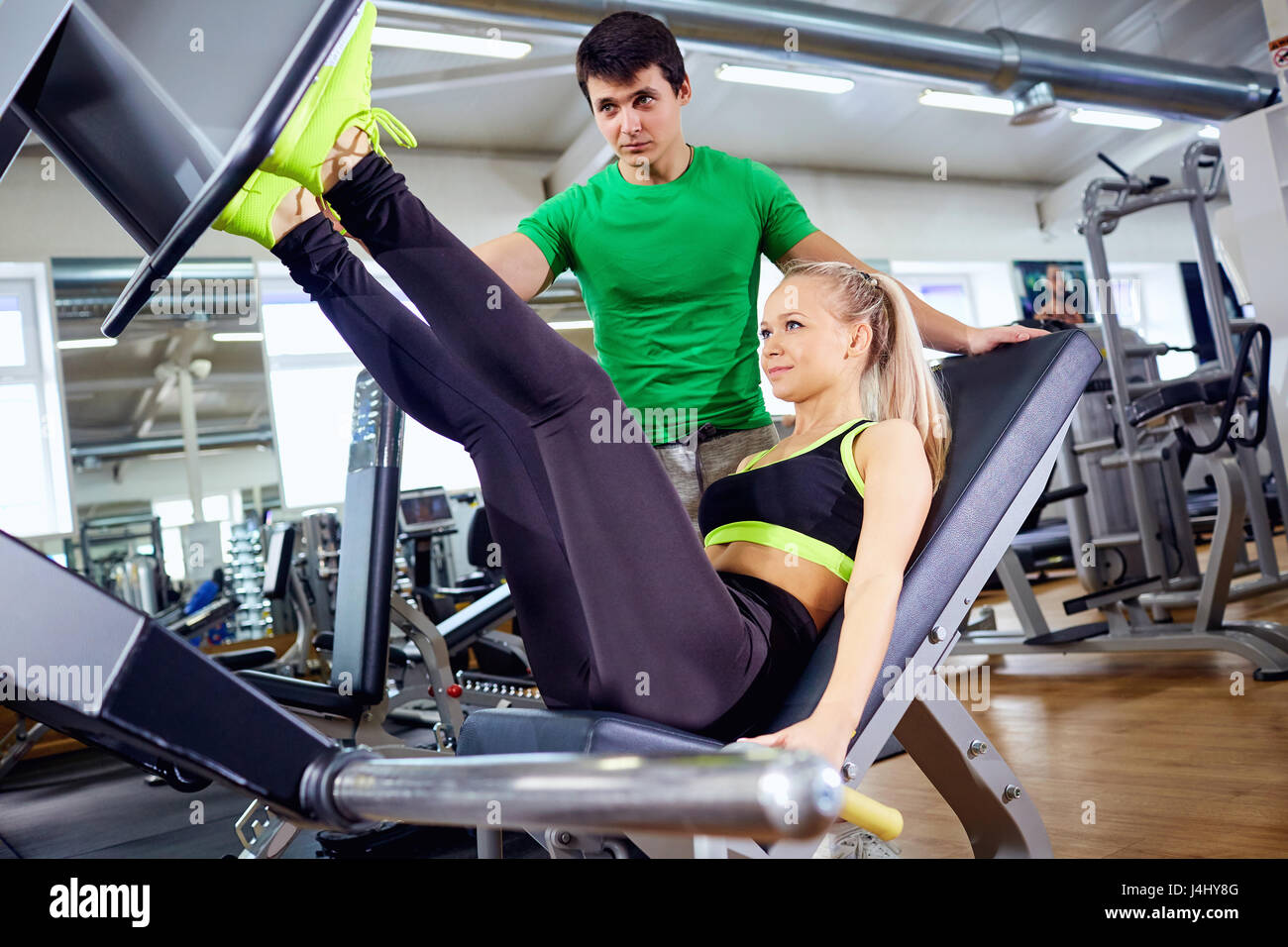 A girl is doing exercises on the foot simulator with personal t Stock ...