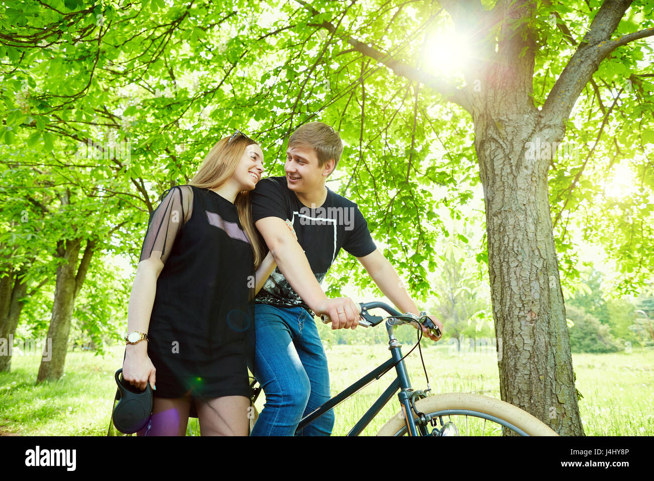 A loving couple on bicycle is smiling in the park Stock Photo - Alamy