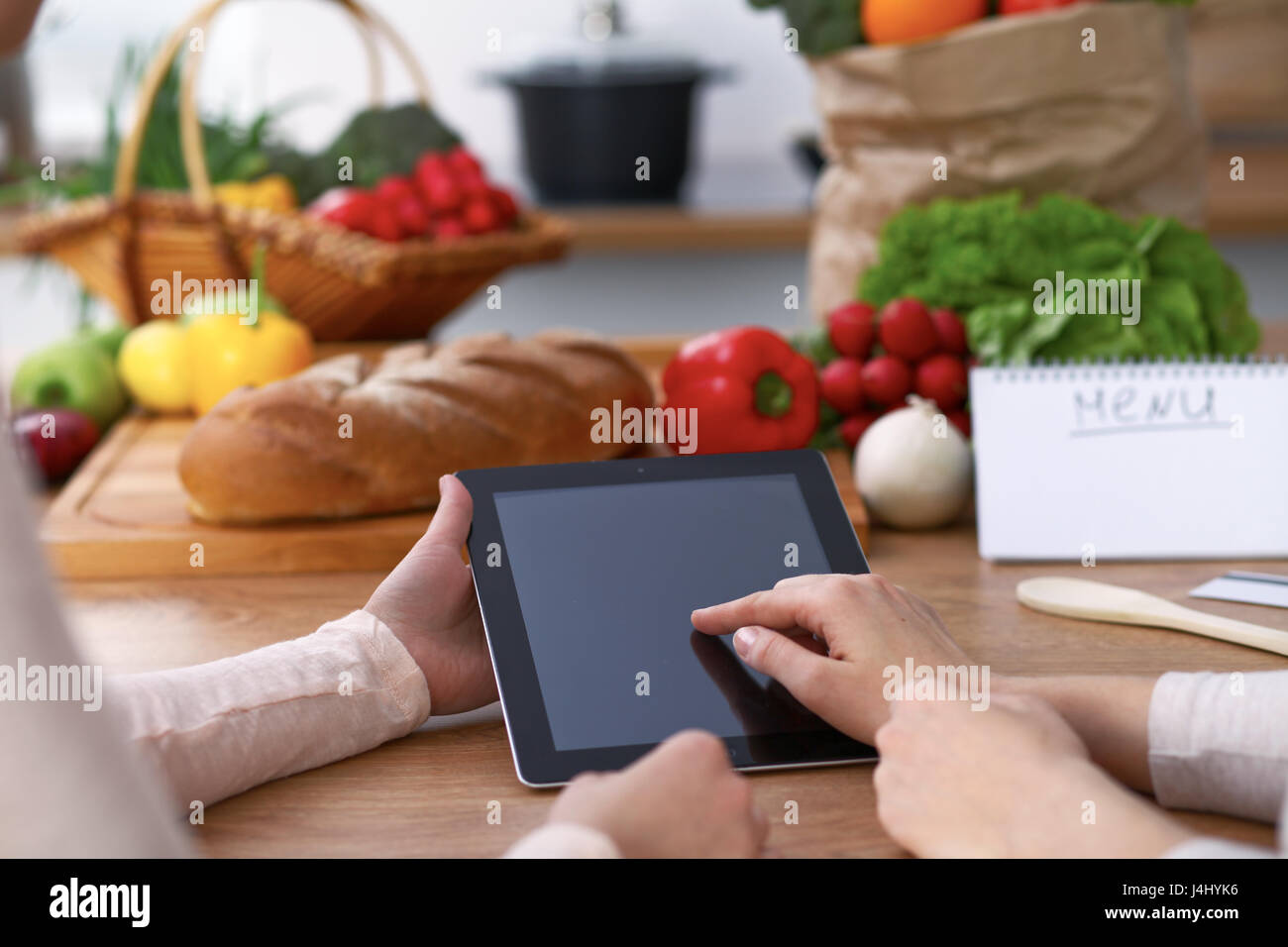 Human hands of two female persons using touchpad for making menu in the ...