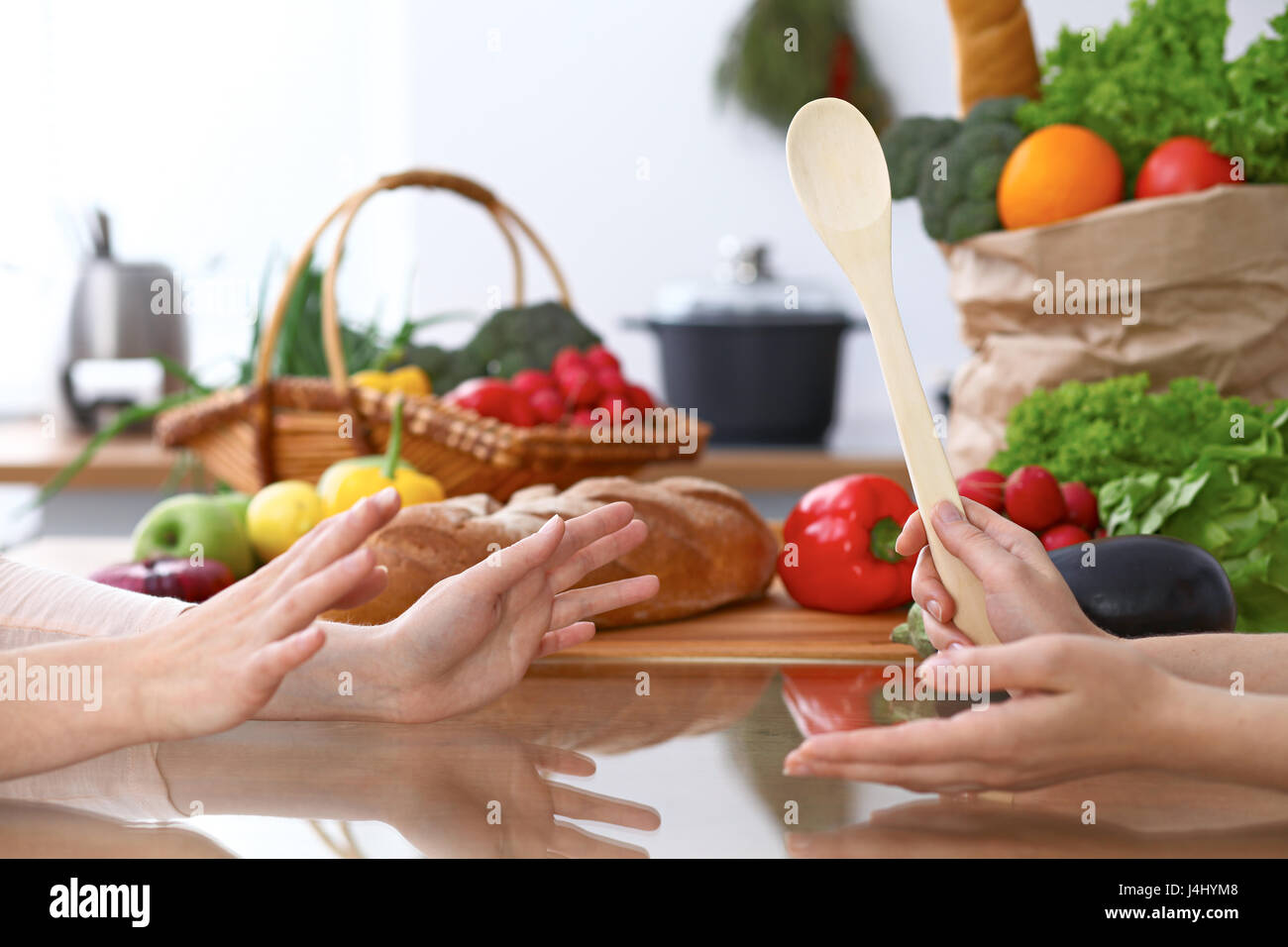 Two women discussing a new menu in the kitchen, close up. Human hands ...