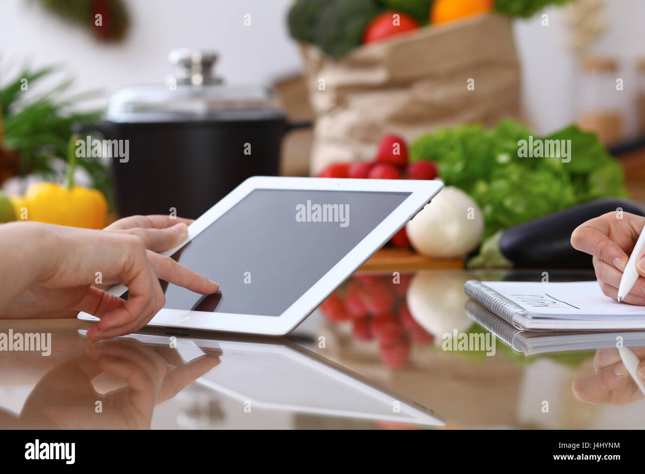 Human hands of two female persons using touchpad for making menu in the ...