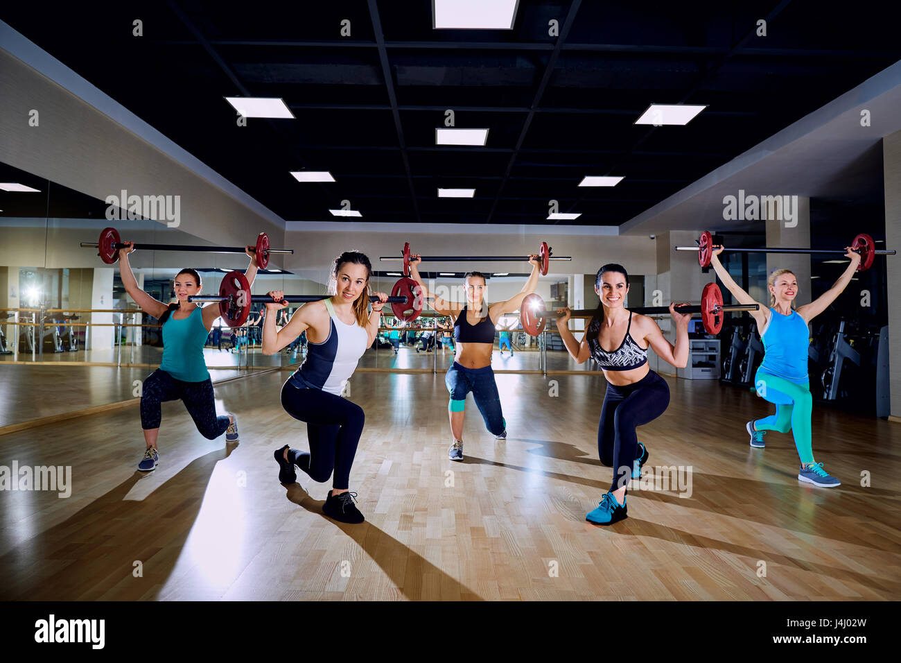 Girls with barbells do group training in the gym Stock Photo - Alamy