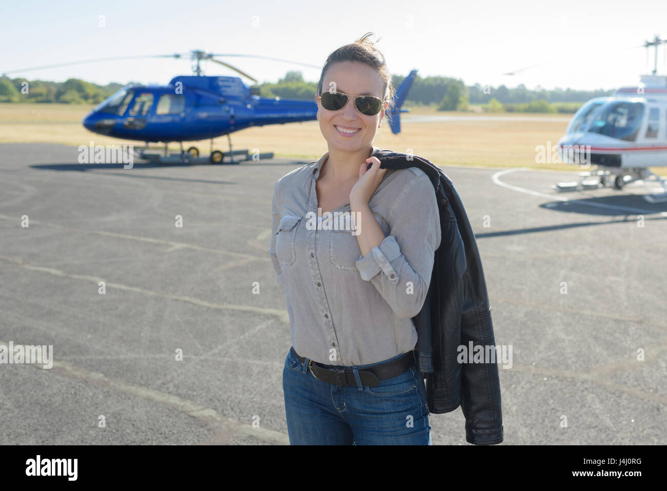pilot woman smiling on helicopter background Stock Photo - Alamy