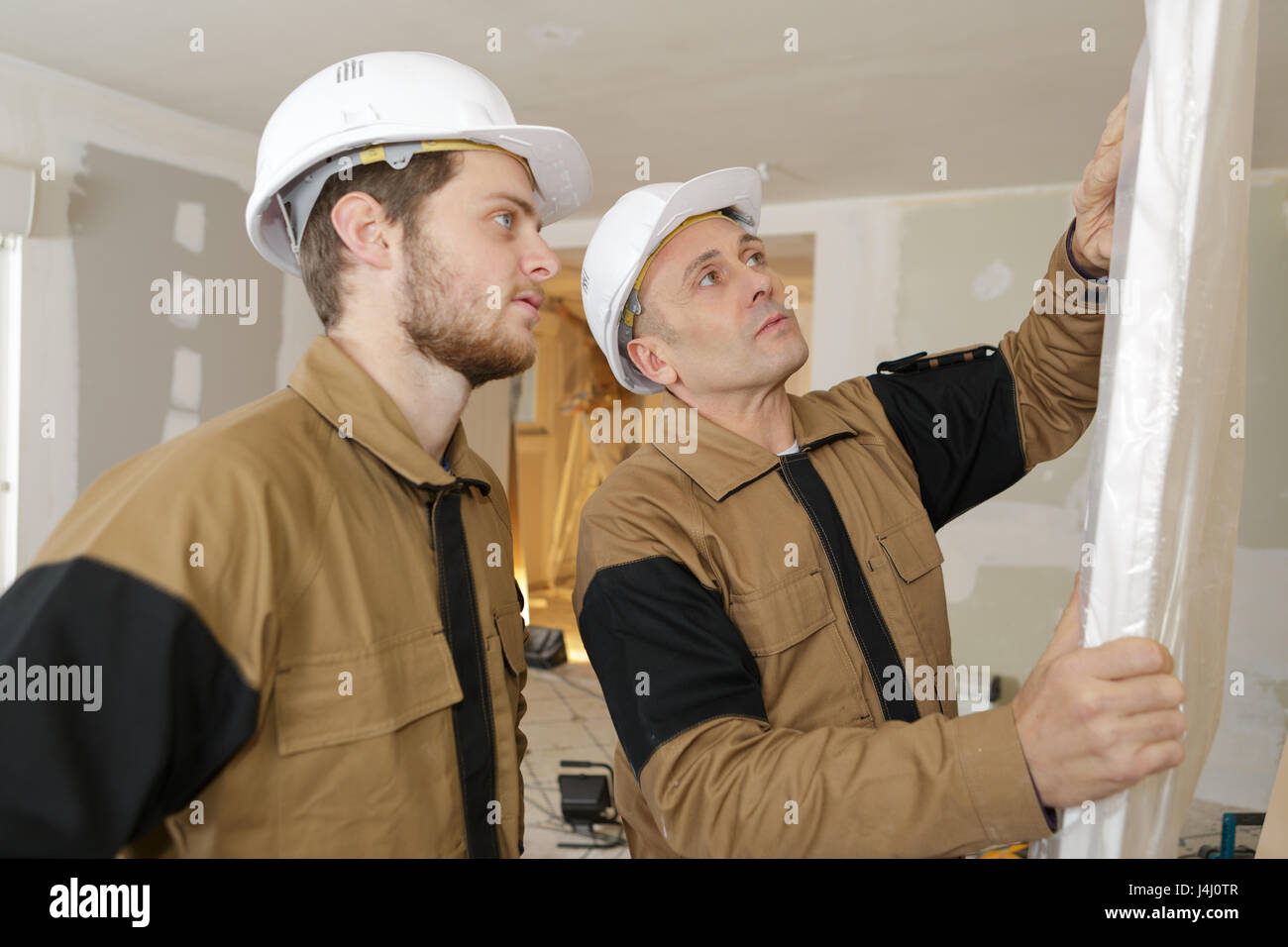 constructor and apprentice verifies correct installation on garage door ...