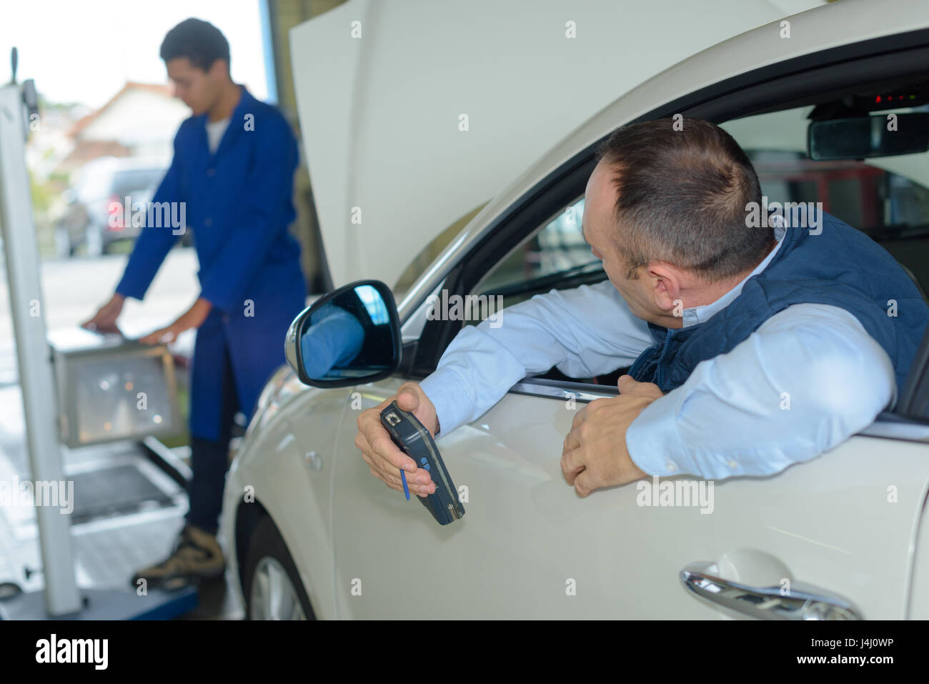 Vehicle inspection being performed in garage Stock Photo - Alamy