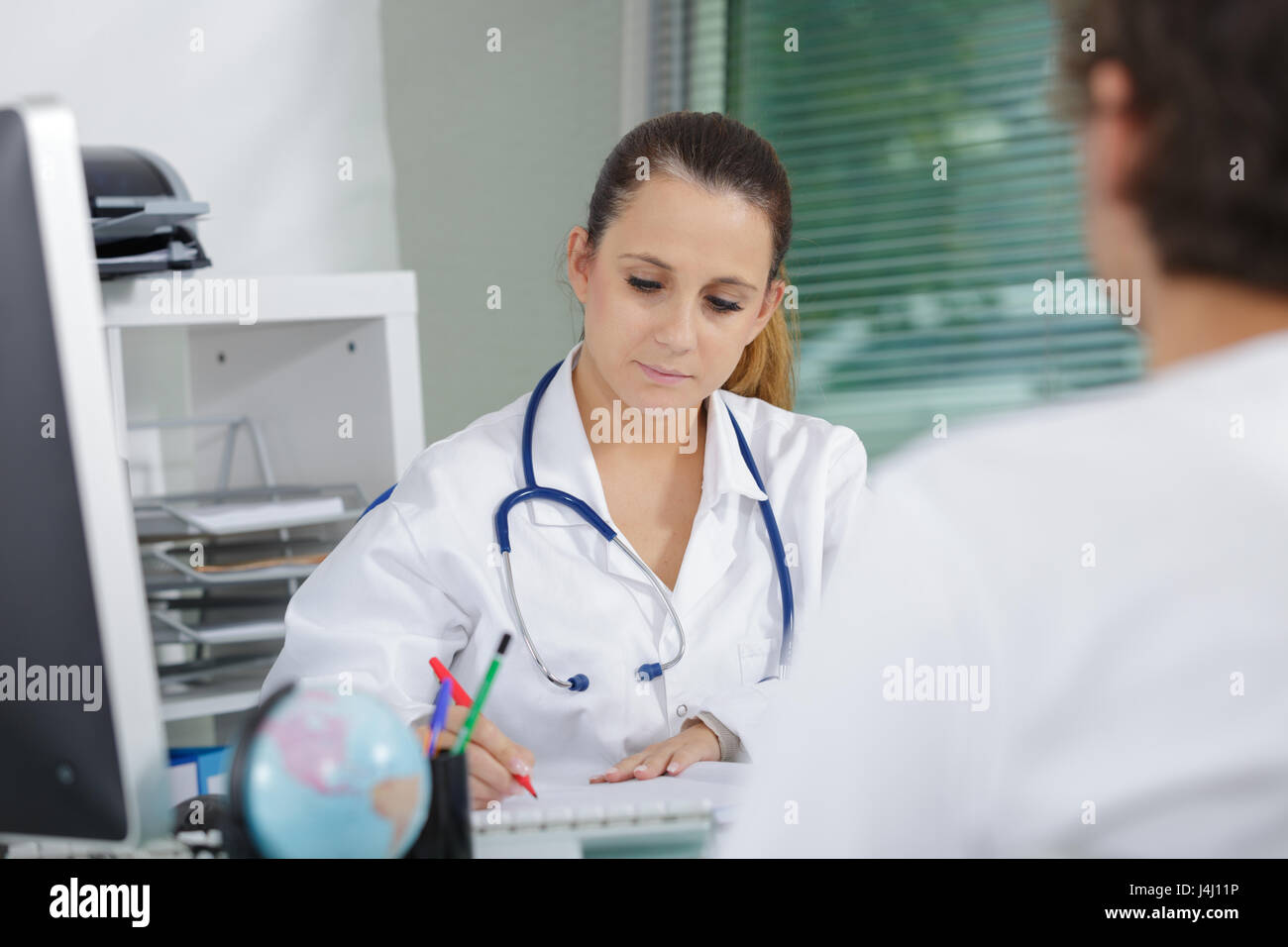 Doctor writing prescription for patient Stock Photo - Alamy