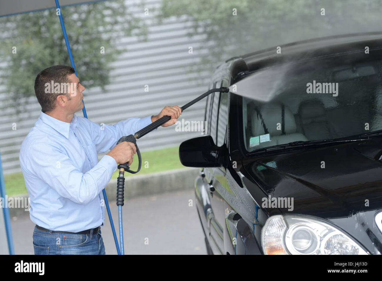 Man power washing vehicle Stock Photo - Alamy