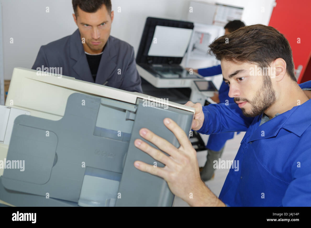 Young man working on office printer Stock Photo - Alamy