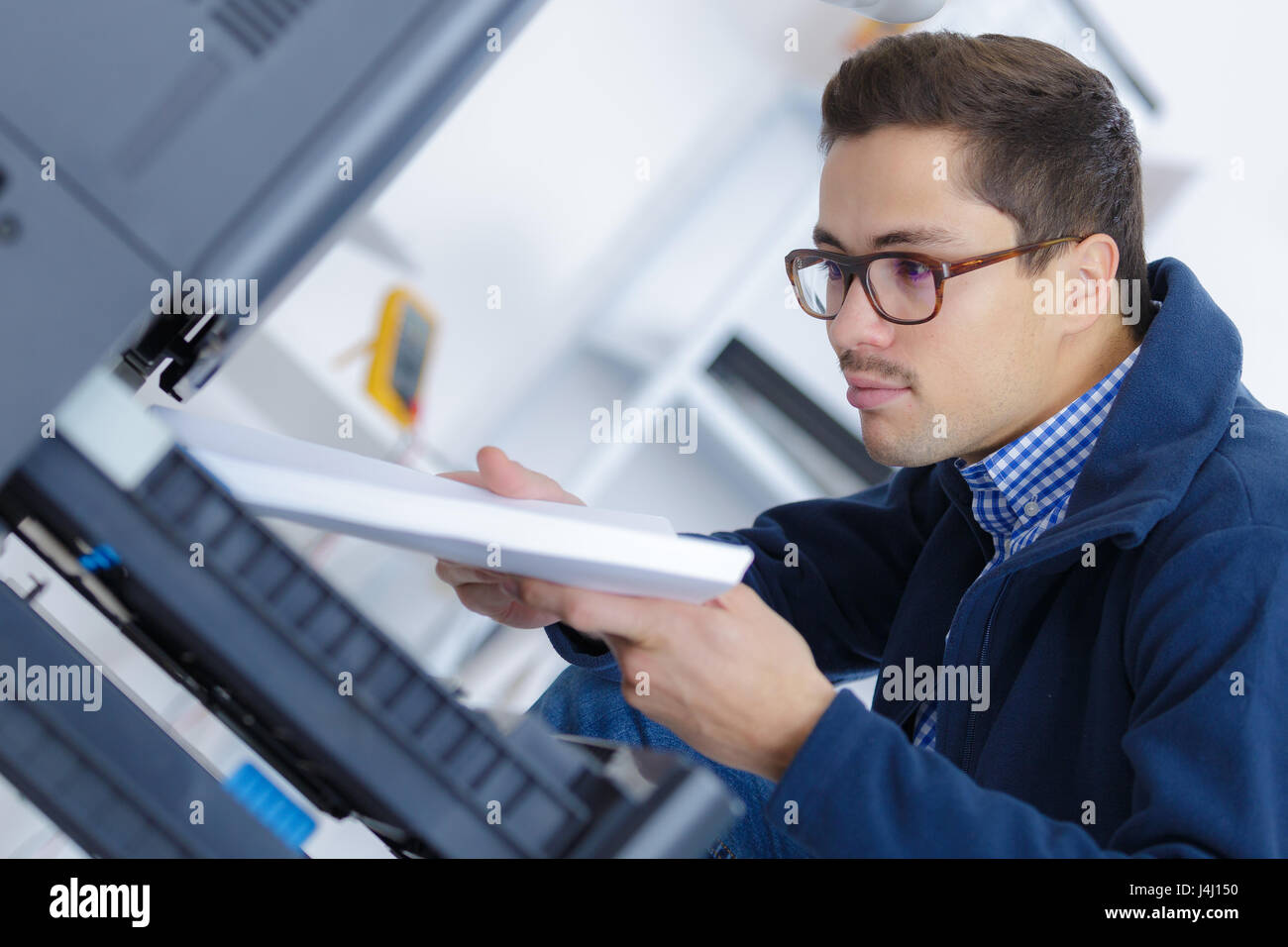Man refilling photocopier paper tray Stock Photo - Alamy