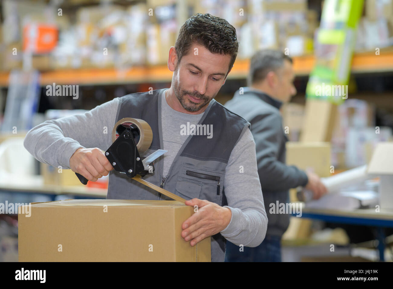 man holding packing machine and sealing cardboard boxes Stock Photo - Alamy