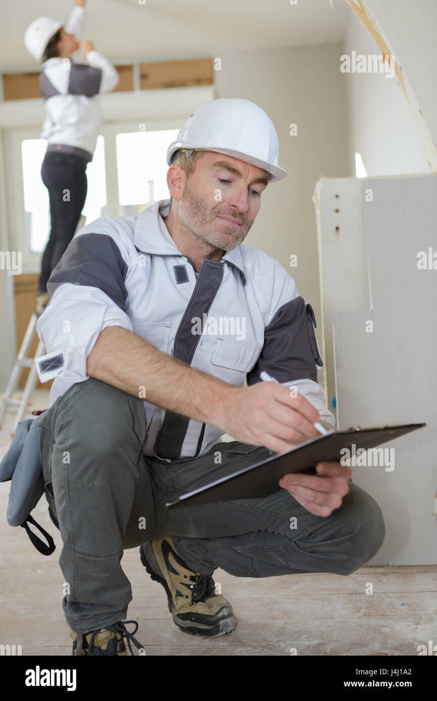 Man with clipboard on worksite Stock Photo - Alamy