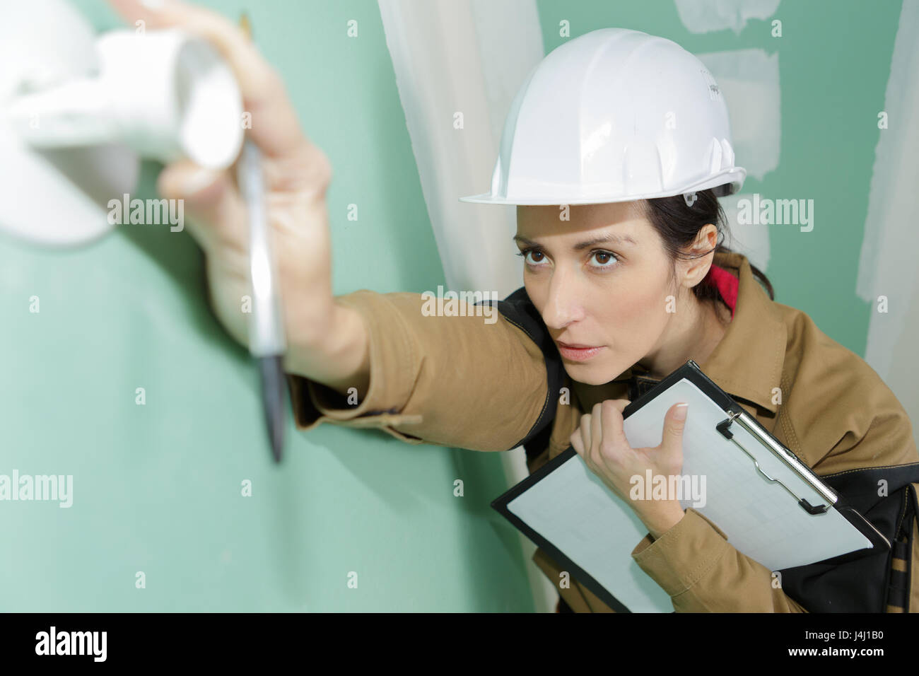 electrician supervisor is checking the installation of a wall socket ...