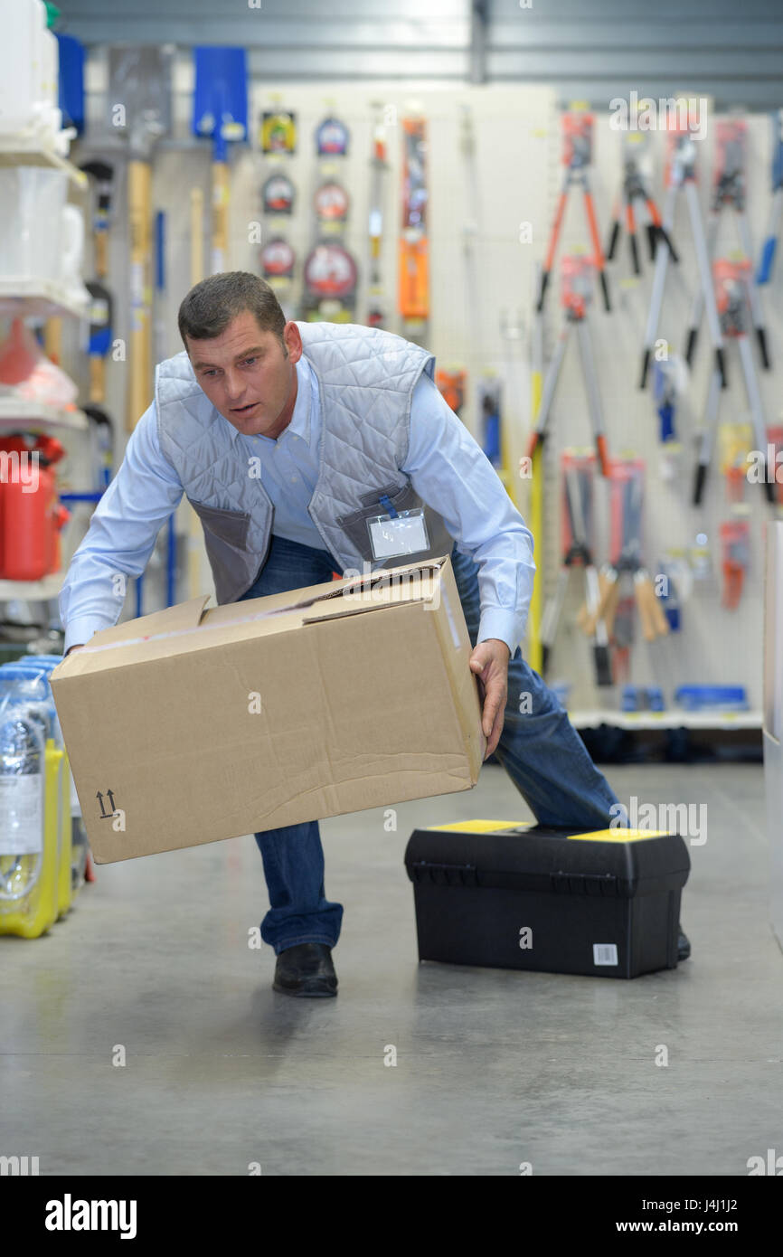 Man stumbling while carrying box Stock Photo - Alamy