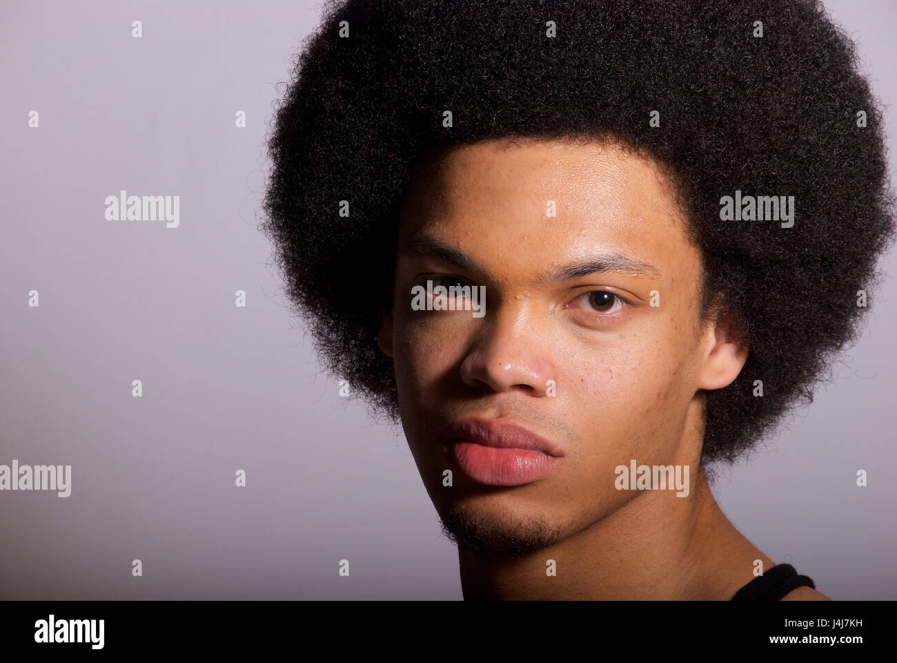 Young black man with afro hairstyle in a studio - head shot Stock Photo ...