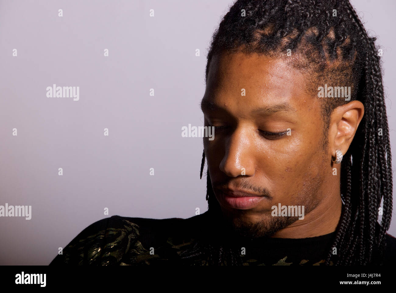 Young black man with braids in a studio - head shot Stock Photo - Alamy