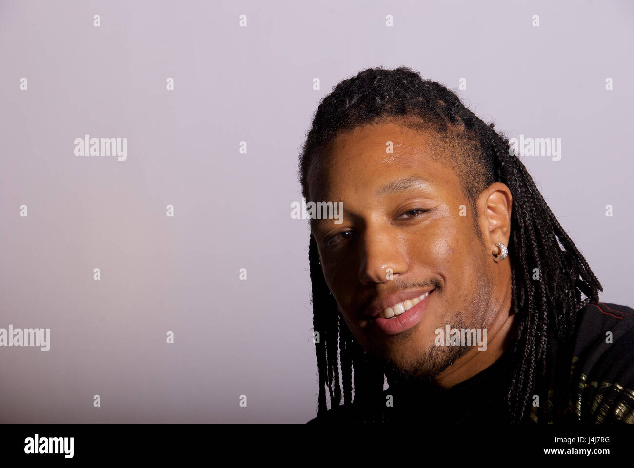 Young black man with braids in a studio - head shot Stock Photo - Alamy