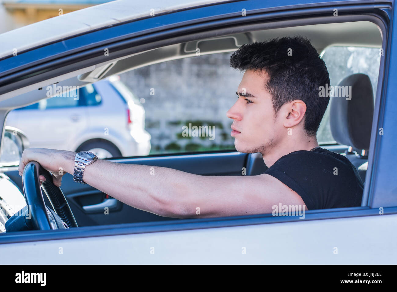 Serious young man or teenager driving car Stock Photo - Alamy