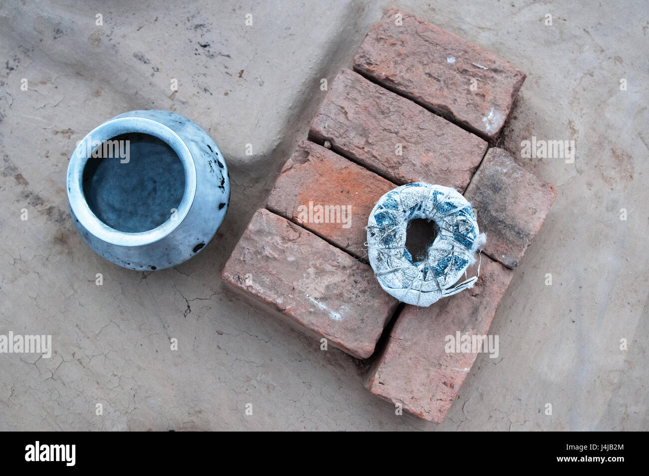 Blue metal round pot, orange and brown rectangular bricks laying ...