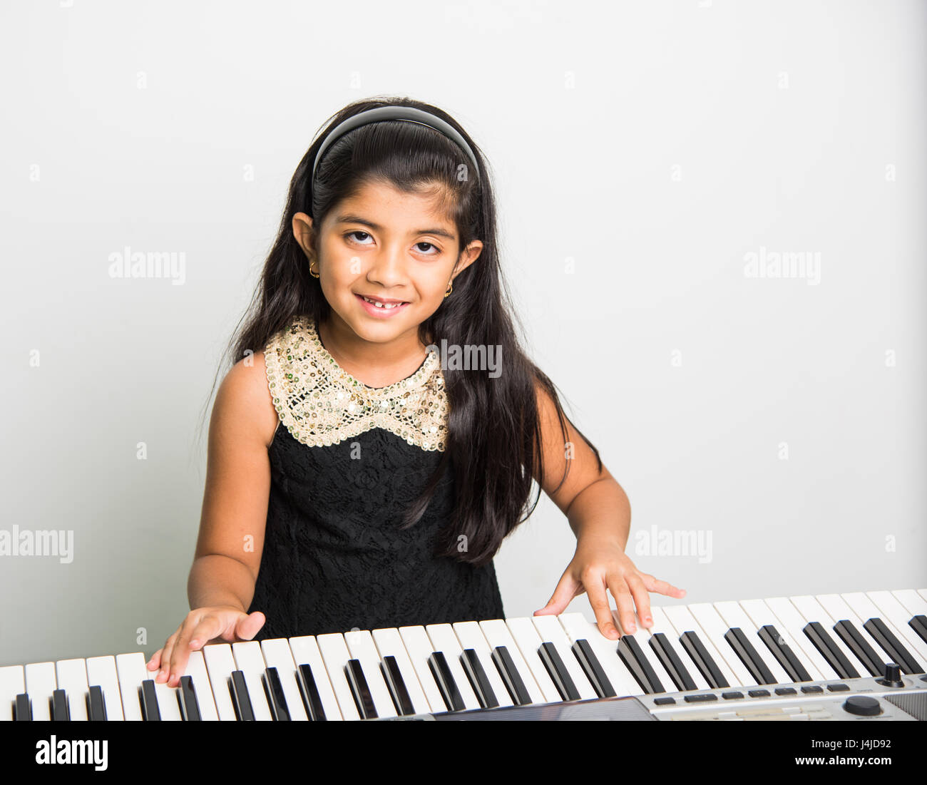 indian kids playing piano or keyboard, a musical instrument, isolated ...