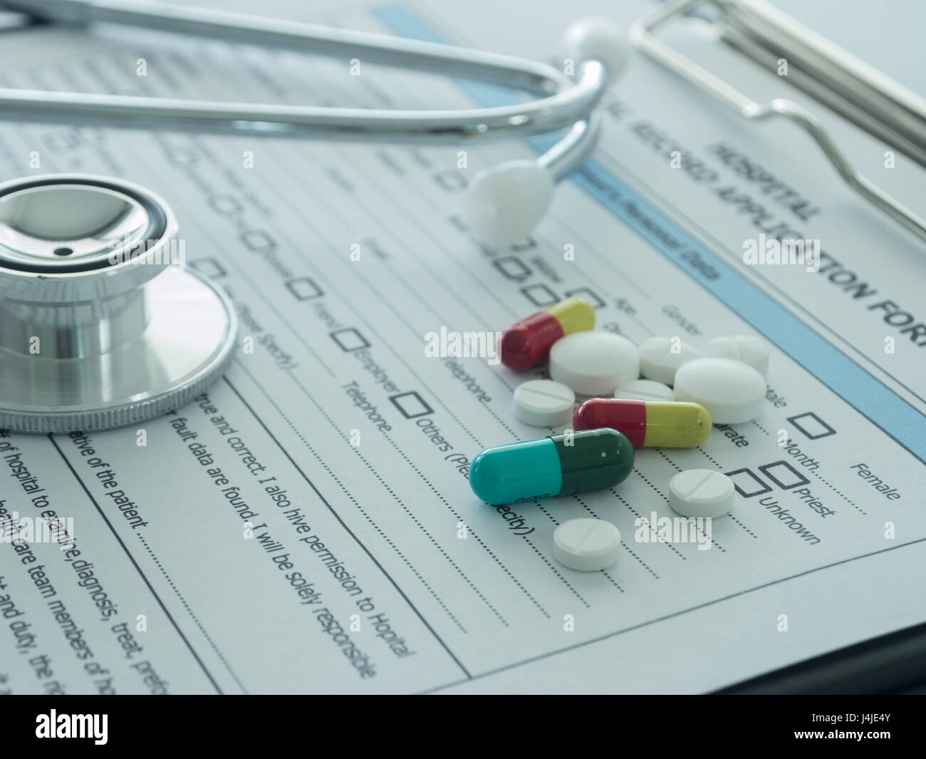 pill with stethoscope , medical record application form on physicians ...