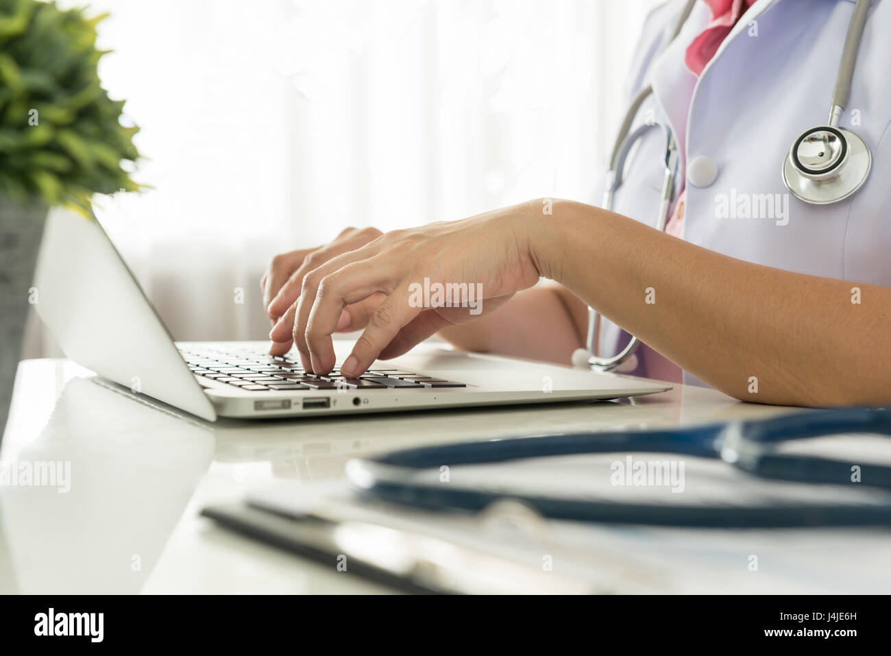 Close-up of a doctor typing on keybord in the office Stock Photo - Alamy