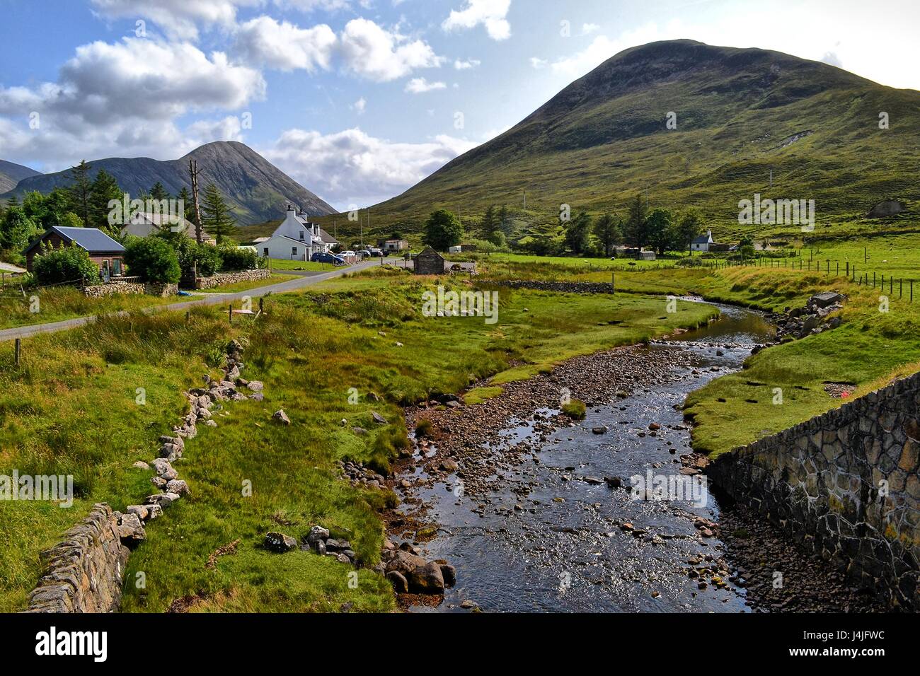 Stream running through village on the Isle of Skye, with hills and ...