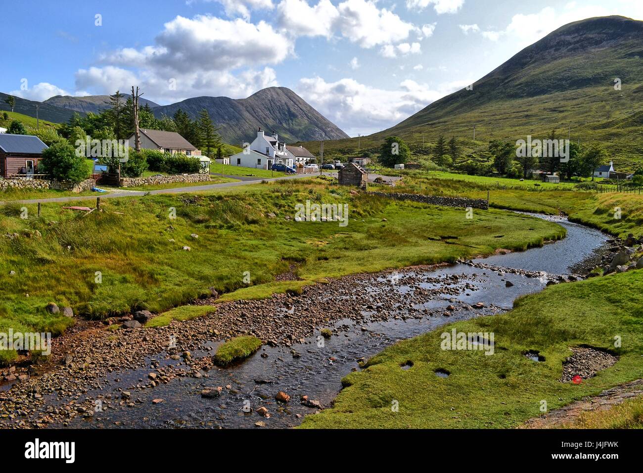 Stream running through village on the Isle of Skye, with hills and ...