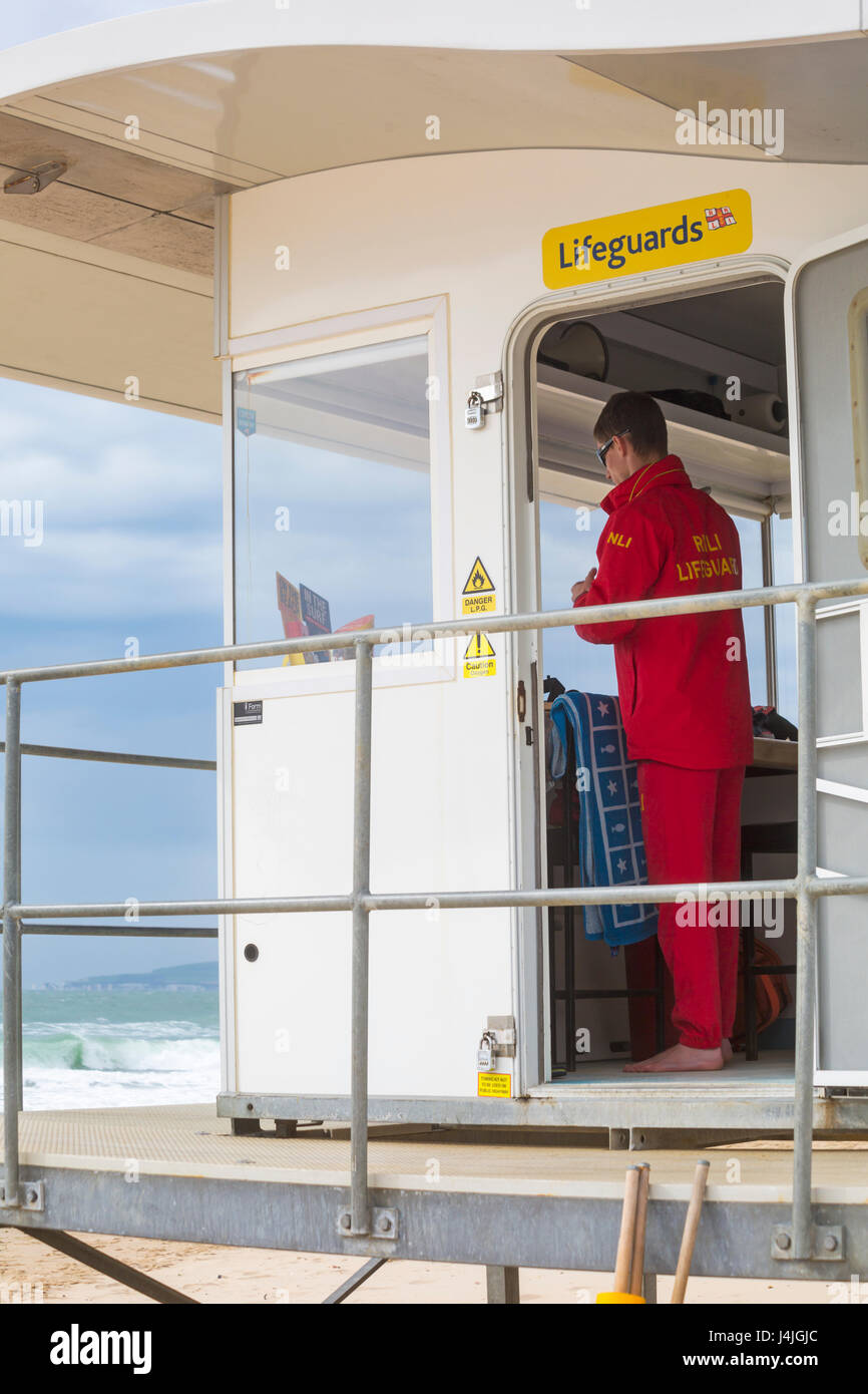 RNLI Lifeguard on duty patrolling the area in RNLI kiosk hut station at ...