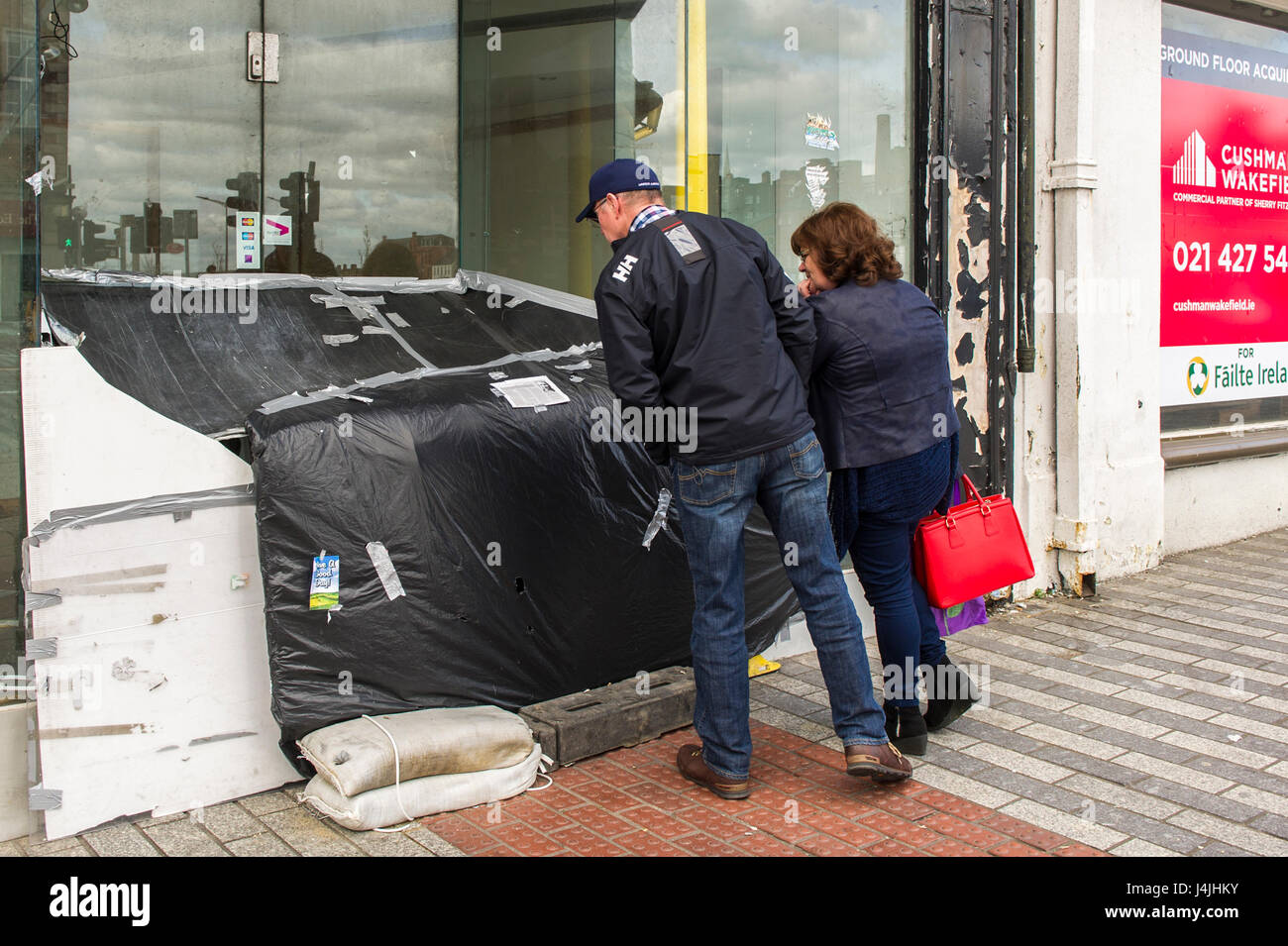 People stop to look at a makeshift homeless shelter on Patrick Street ...