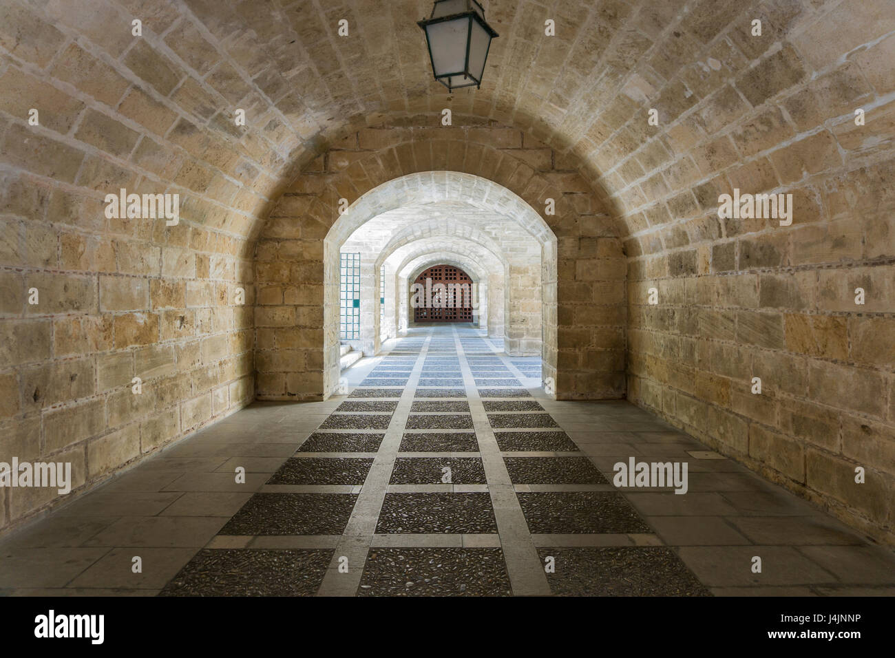 Old building corridor with grilled door at the end Stock Photo - Alamy