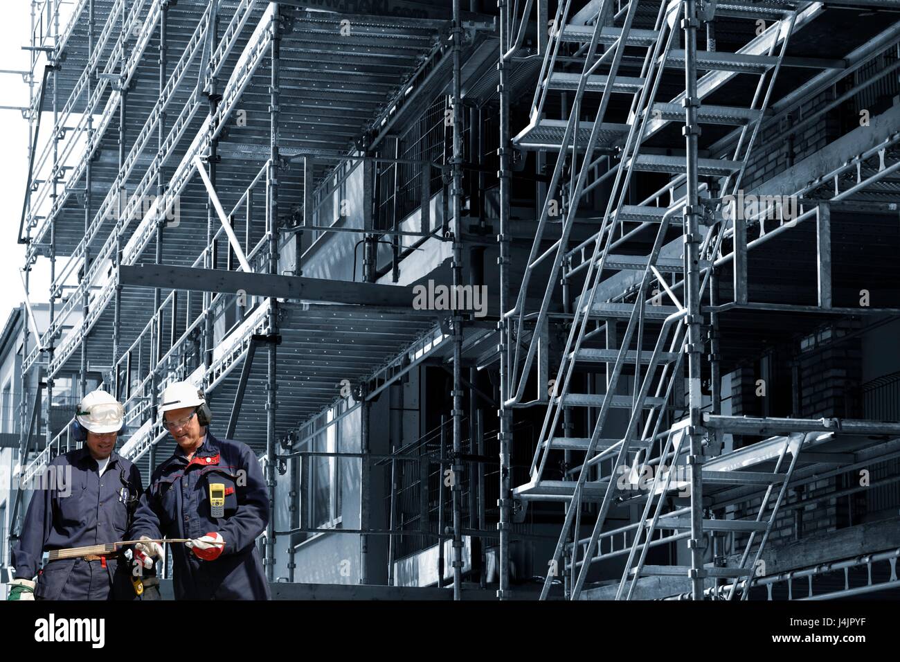 Construction workers on site with scaffolding on building Stock Photo ...