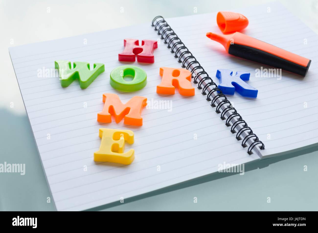 Colourful letters on notebook spelling homework Stock Photo - Alamy