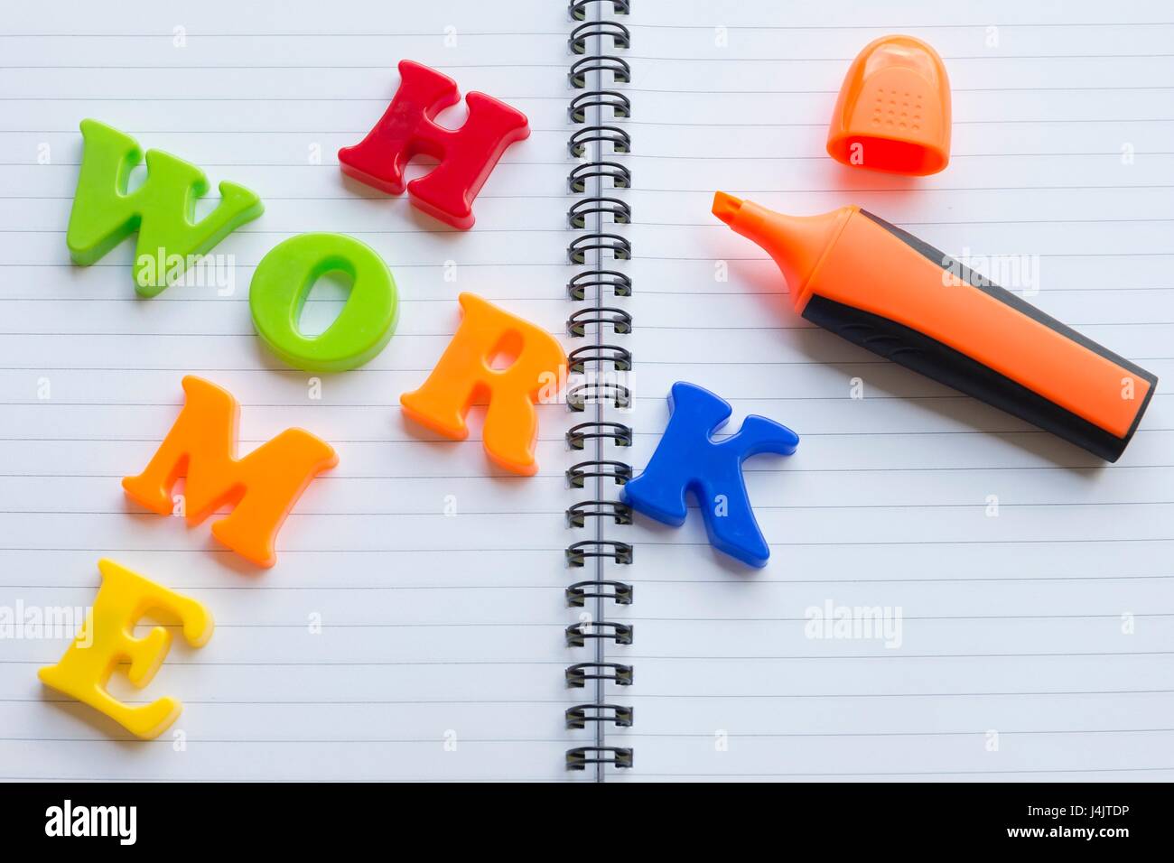 Colourful letters on notebook spelling homework Stock Photo - Alamy