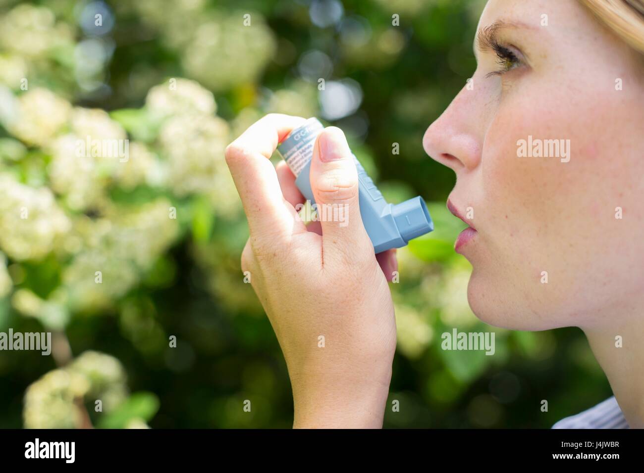 Young woman using inhaler Stock Photo - Alamy