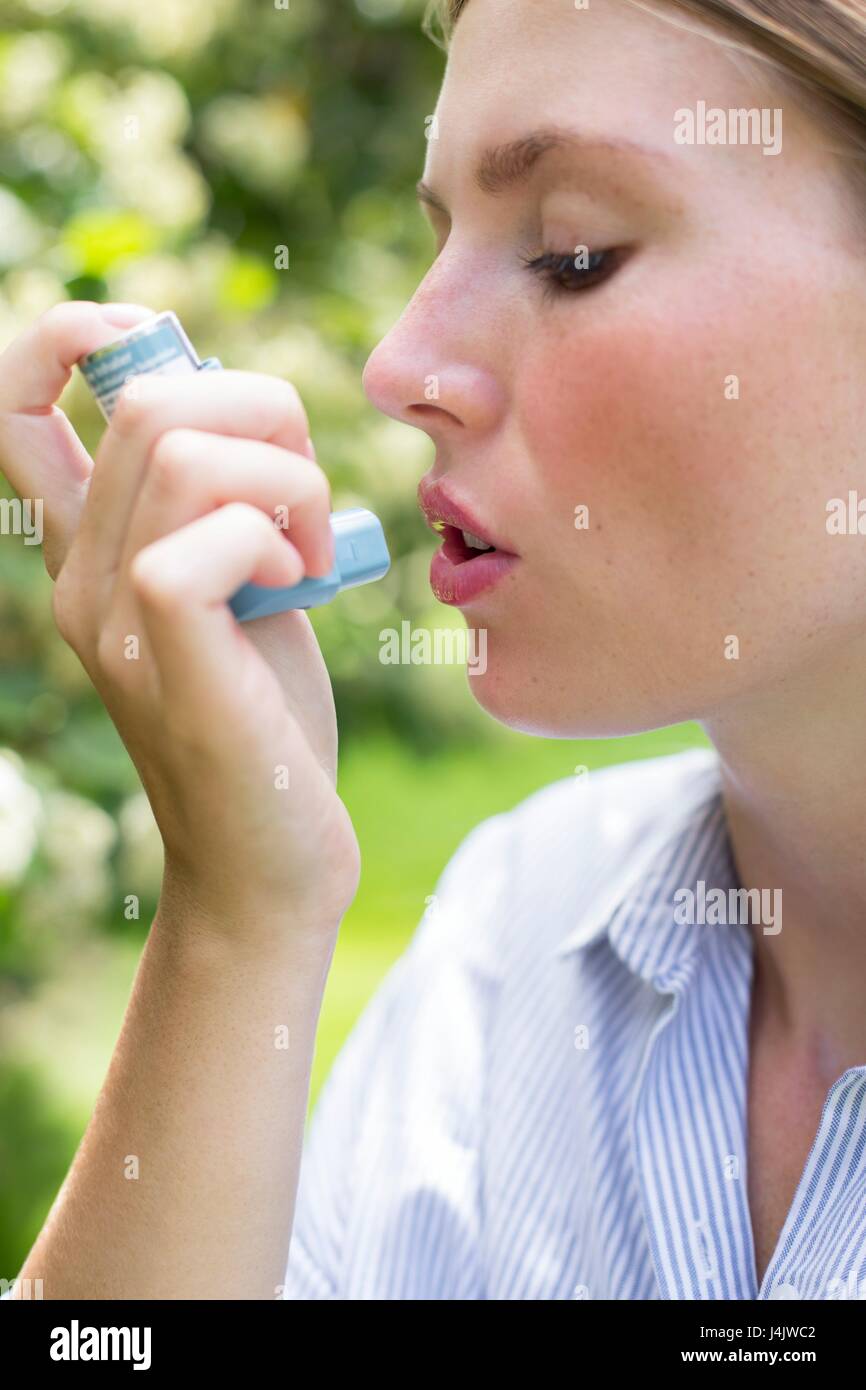 Young woman using inhaler Stock Photo - Alamy