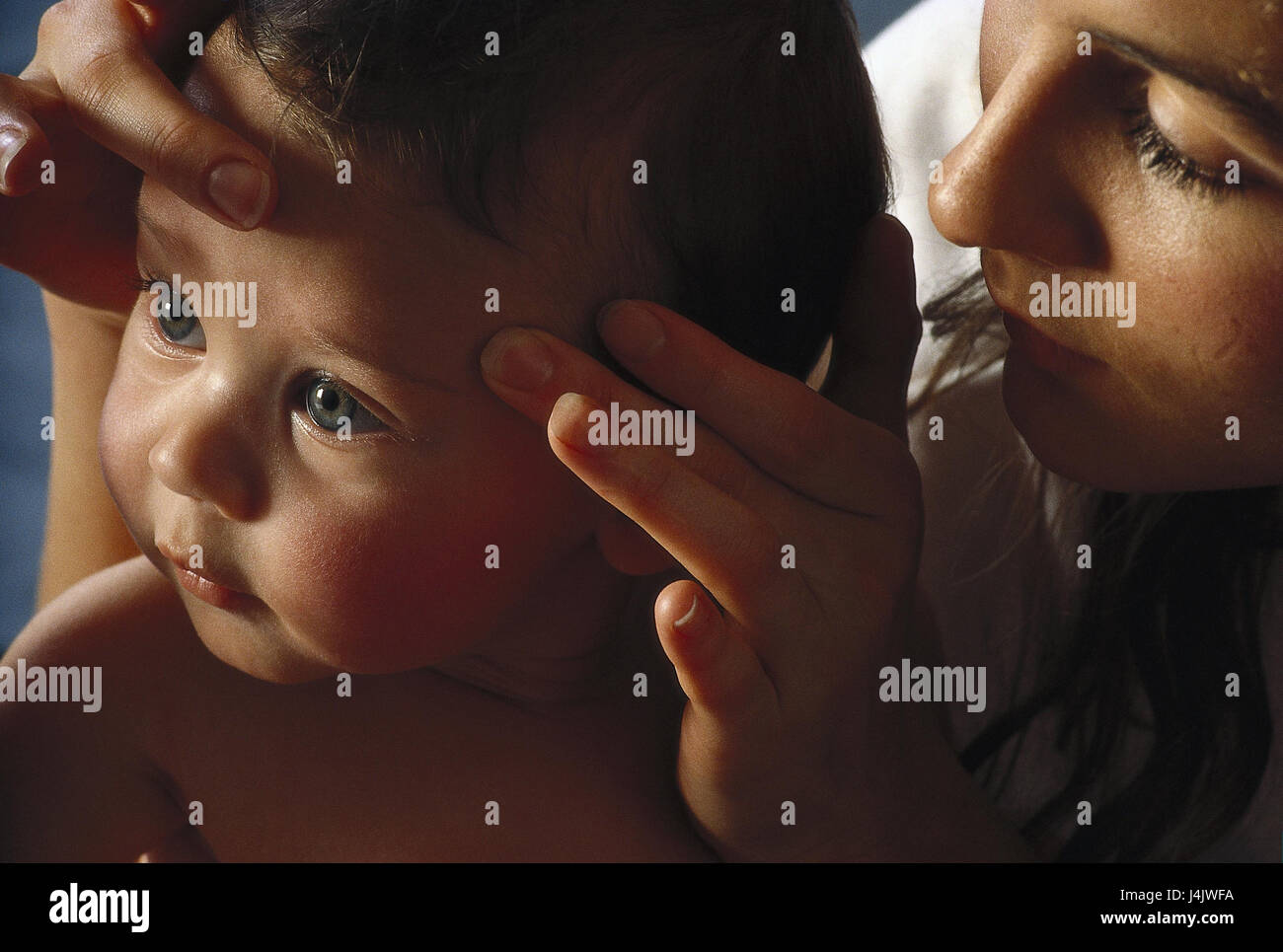 Mother, baby, forehead, temples, massage, portrait very closely, woman ...