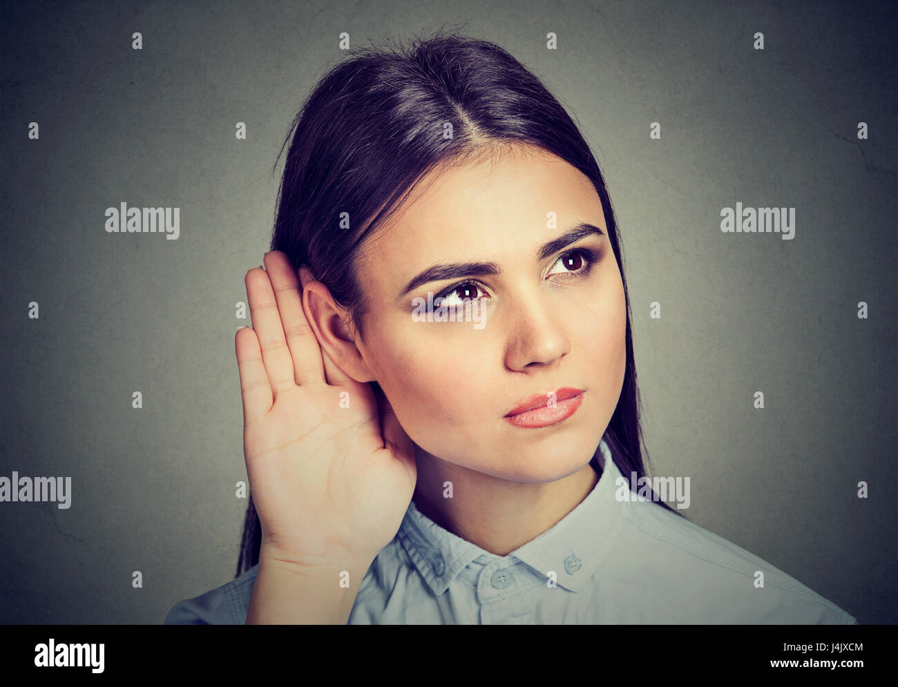 Woman with hand to ear gesture listening carefully Stock Photo - Alamy