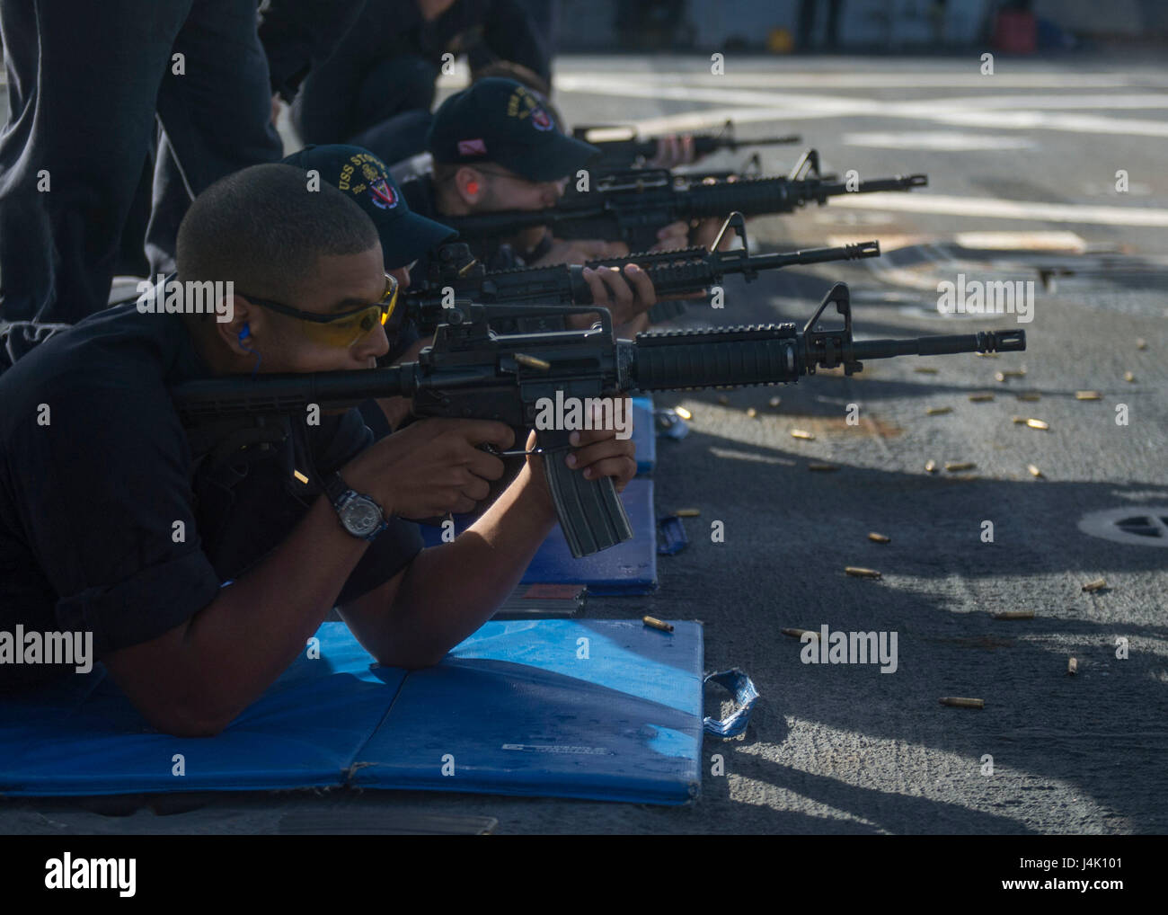 Sailors fire an M4 rifle aboard USS Stout (DDG 55) during a live-fire ...