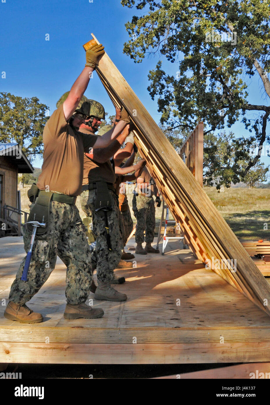 Sailors from Naval Mobile Construction Battalion 18 (NMCB 18) lift a ...
